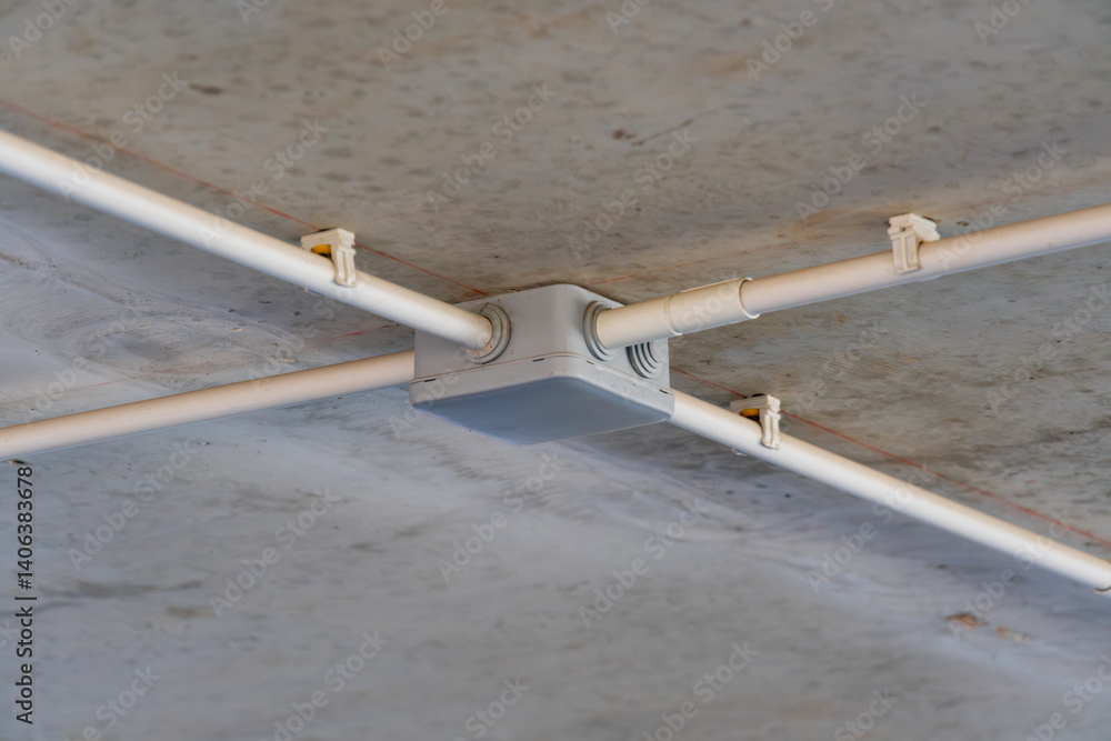Metal junction box connects various conduit pipes overhead in a ...