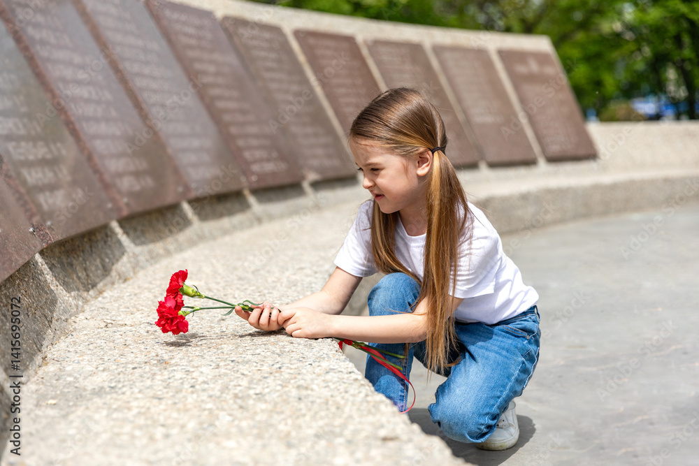 The memory of soldiers in Great Patriotic War. Little girl laying red ...