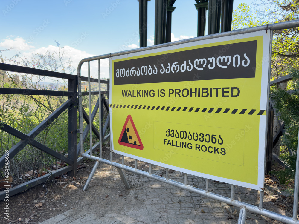 Warning sign in Georgian and English languages saying walking is ...