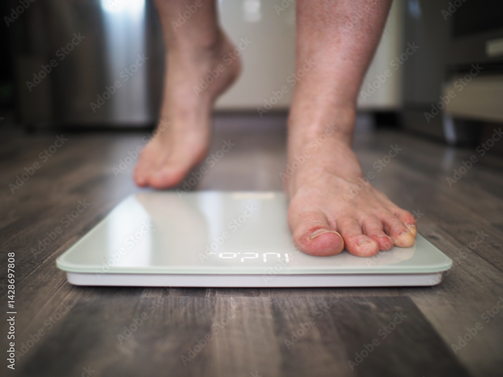 Men's feet step on scales to determine weight change, effectiveness of ...