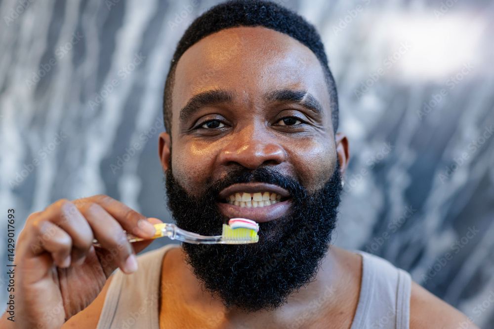African American man brushing teeth in bathroom, with toothbrush and ...