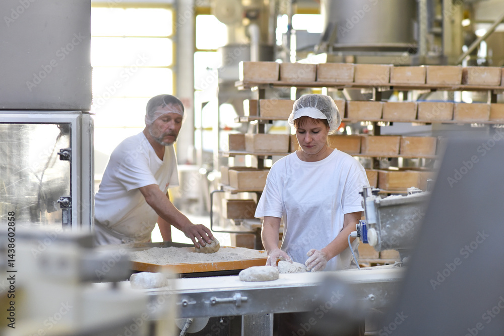 Worker in a large bakery - industrial production of bakery products on ...