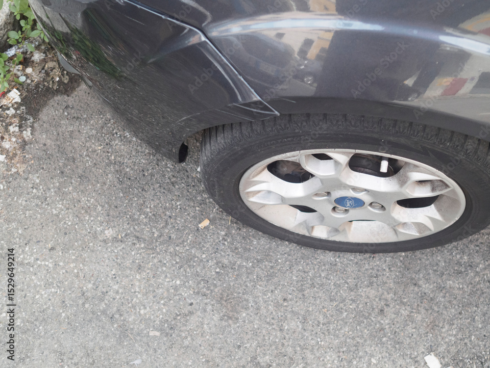 Ford Focus wheel positioned on textured asphalt surface, revealing ...