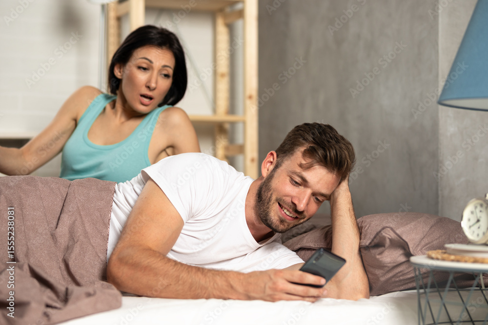 Cheating husband texting on phone ignoring wife lying in bed. Stock ...