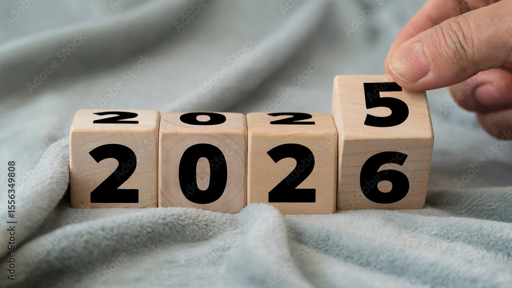 Hand flipping wooden cube from 2026 to 2025 signifying change and transition to a new year Stock ...