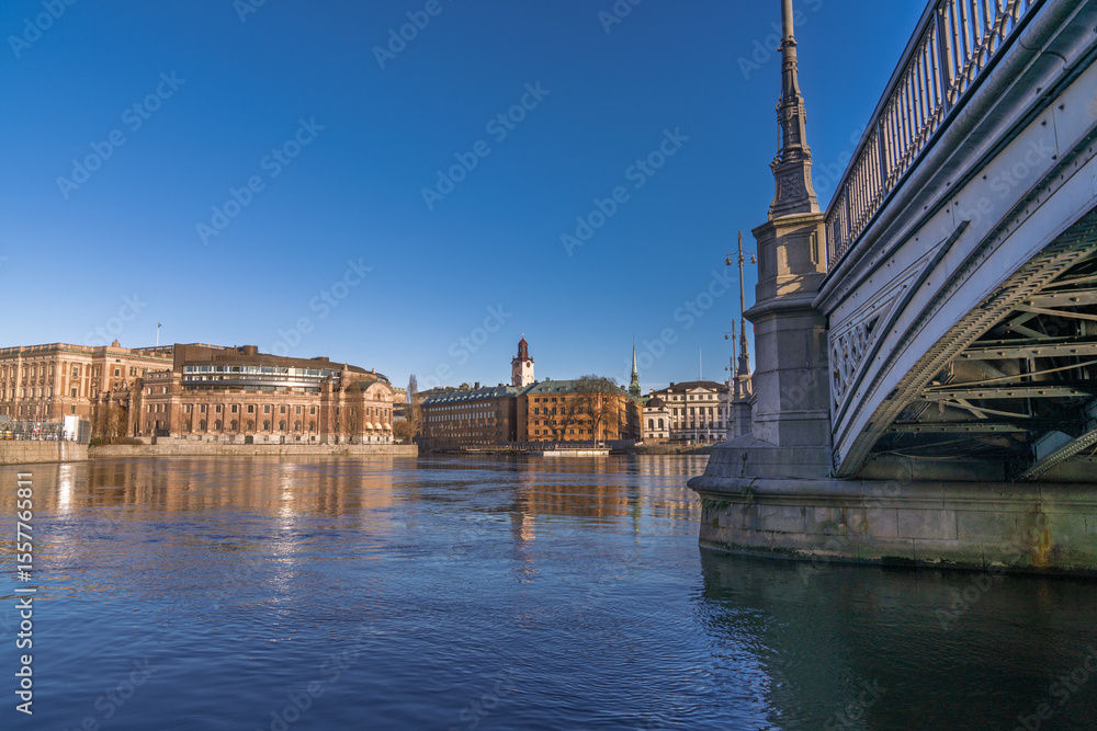 Swedish Parliament building reflected in water with bridge and skyline ...