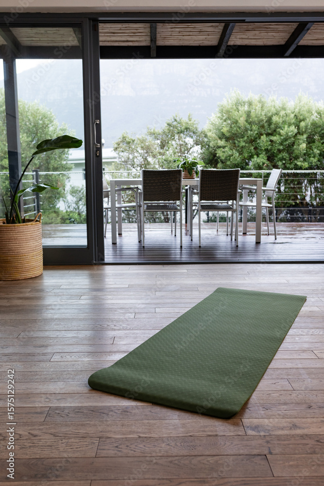 Green yoga mat lying on floor near glass door, revealing deck featuring ...