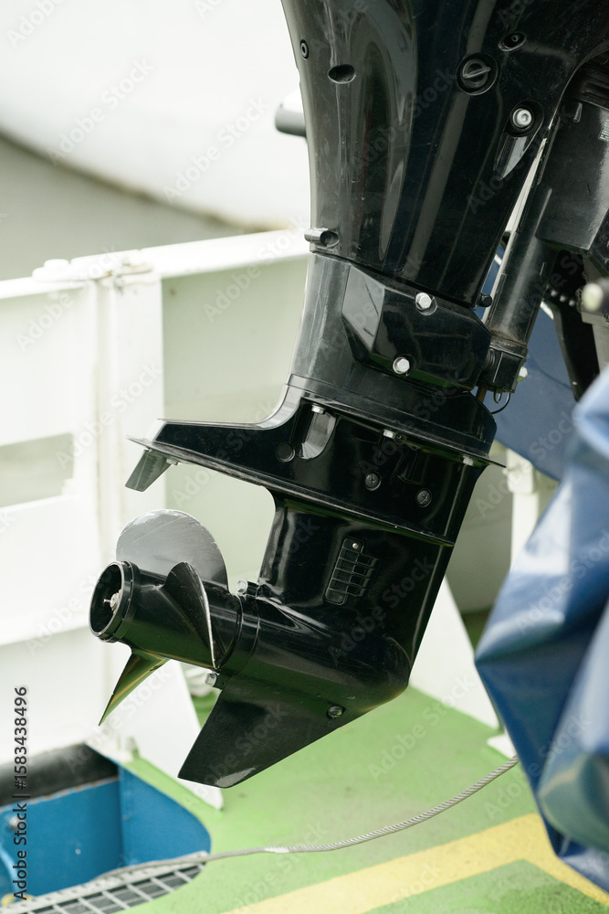 Black outboard motor lower unit with metal propeller generates ...