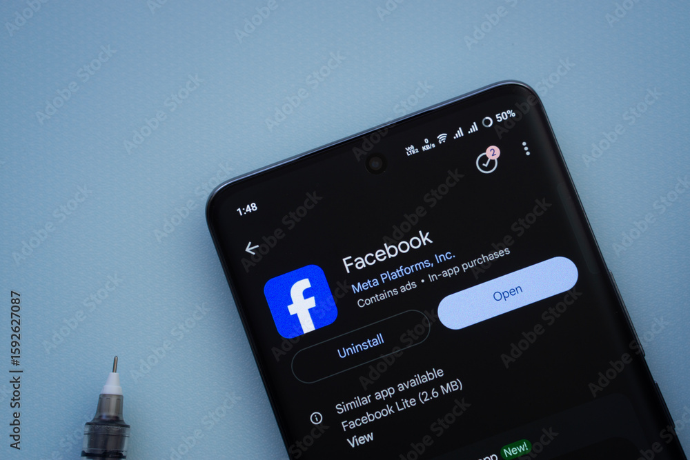 Dhaka, Bangladesh- 29 May 2025: On a blue surface, a smartphone displays the Facebook app within ...