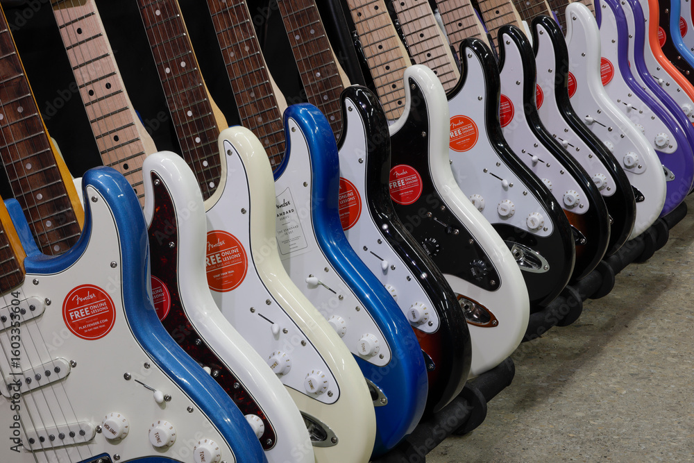 Fender Stratocaster guitar display at a music store. Strats are world ...