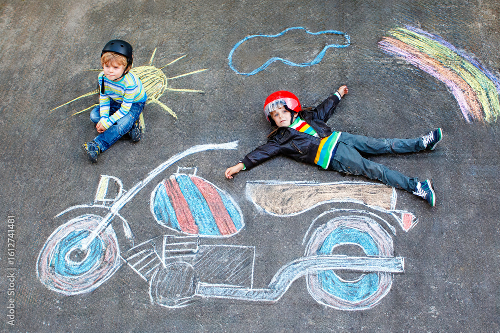 Two funny preschool boys wearing helmets drawing a motorcycle with ...