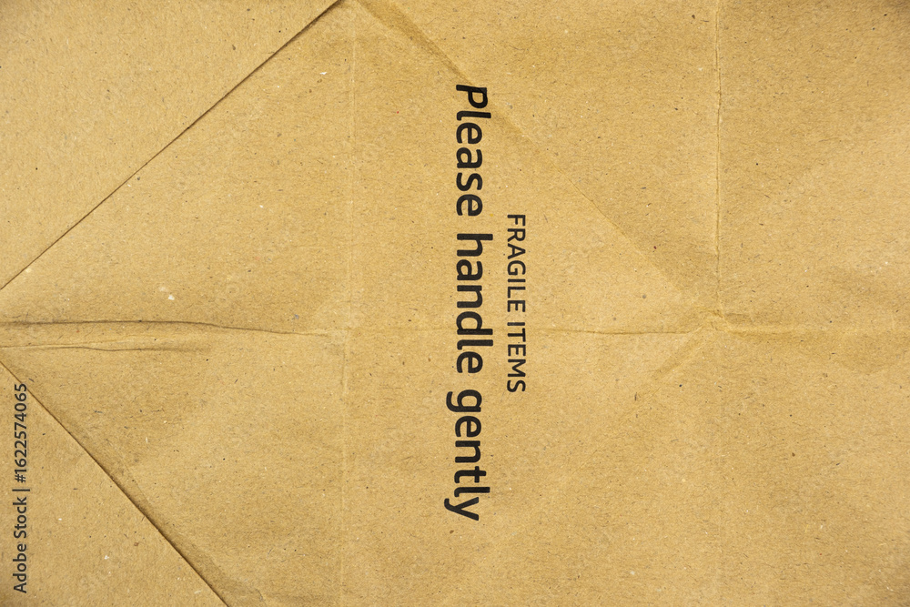 Brown kraft paper with printed warning text saying please handle gently ...