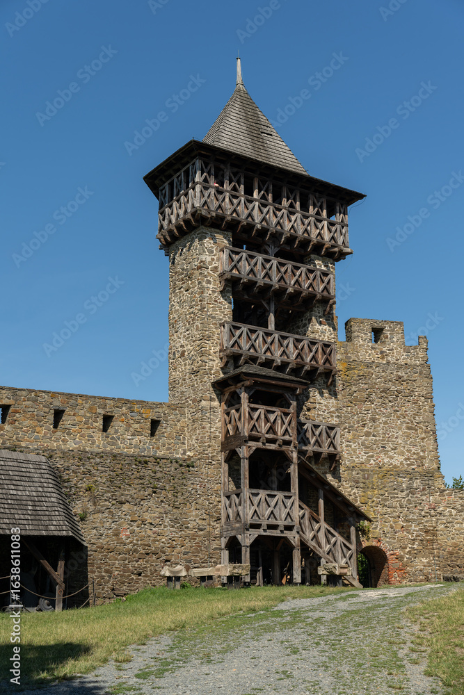 Old castle tower with a roof and wooden structure featuring a staircase ...