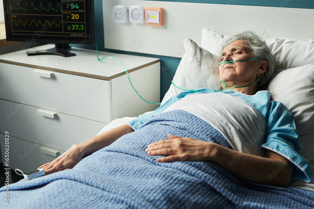 ภาพถ่าย Stock Senior Caucasian woman lying in hospital bed with oxygen ...