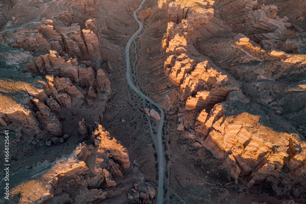 Aerial view of winding road crossing Charyn canyon at sunset, creating ...