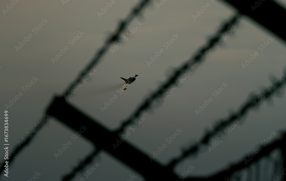 Fighter jet in mid-air, performing a high-speed pass with smoke trails ...