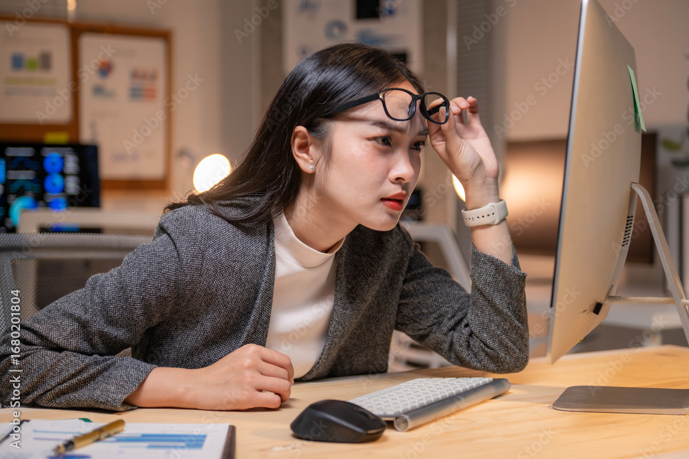 Stressed asian businesswoman having problem reading computer screen at ...