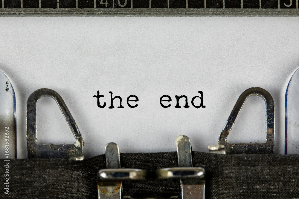 Closeup of a blue retro typewriter and the text the end written with it ...