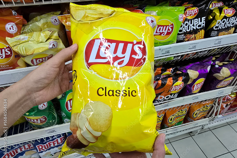 Penang, Malaysia – Aug 8, 2025: A shopper holding a pack of Lay’s ...