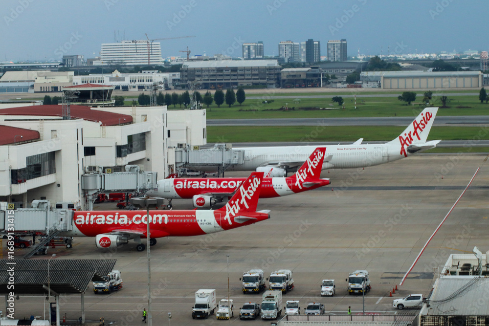 Stock-Foto „Lineup of AirAsia planes at an airport terminal, with two ...