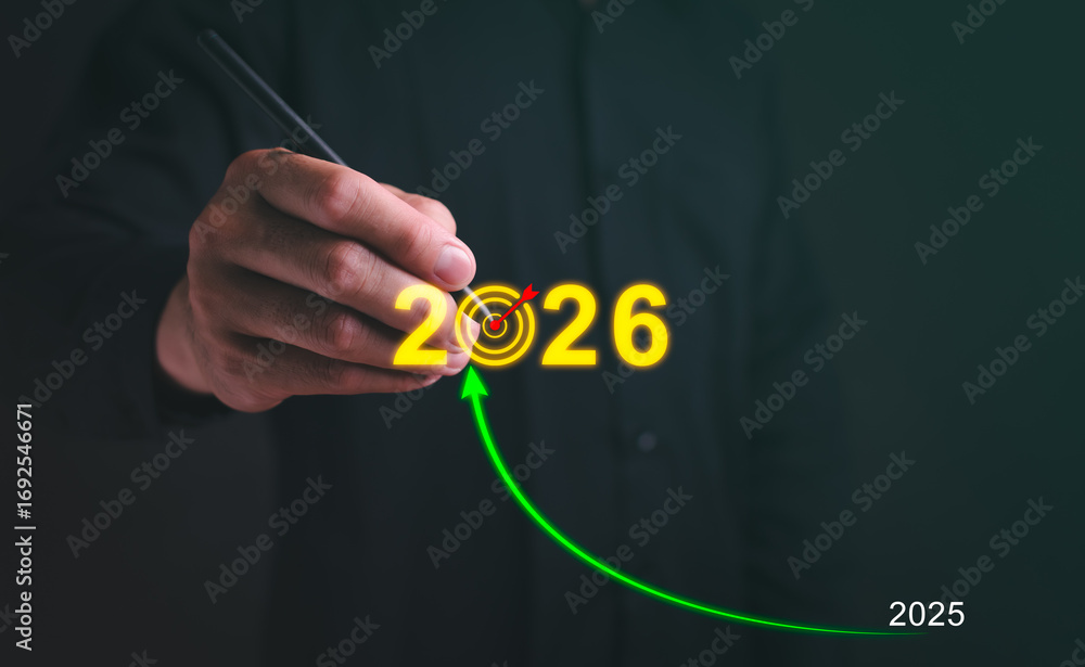 Businessman planning for 2026 strategic growth goals with arrow target ...