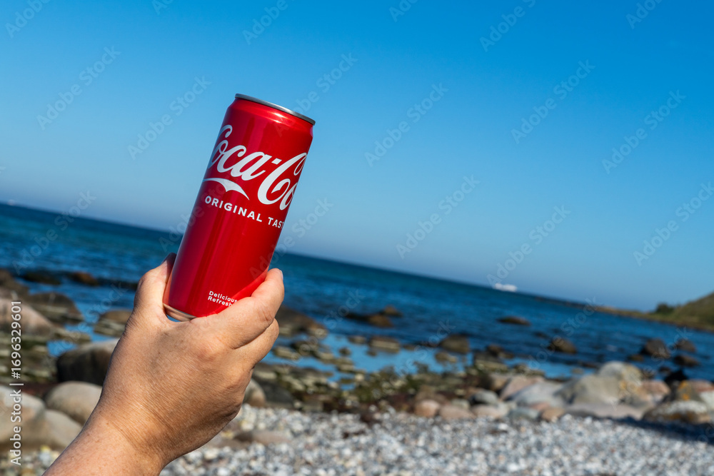 Frau hält Coca Cola Dose im Sommer am Strand am 4. September 2025 an ...