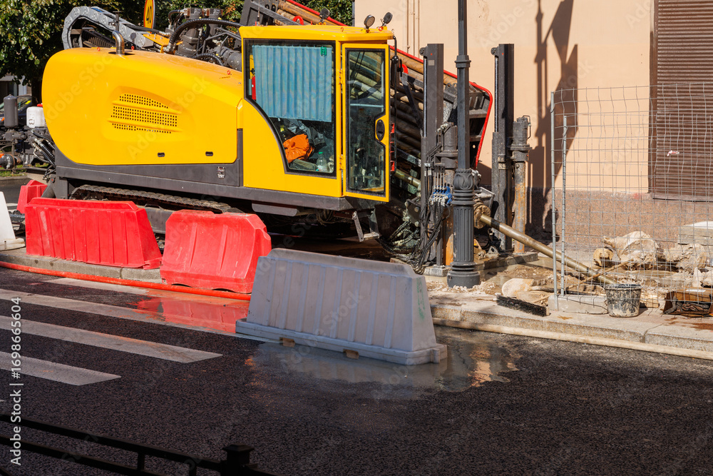 A horizontal directional drilling rig is operating on a city street ...