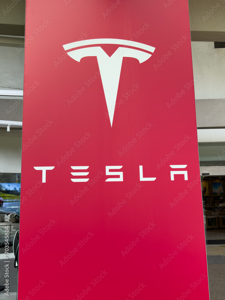 Red signage displays Tesla logo and brand name prominently in a ...