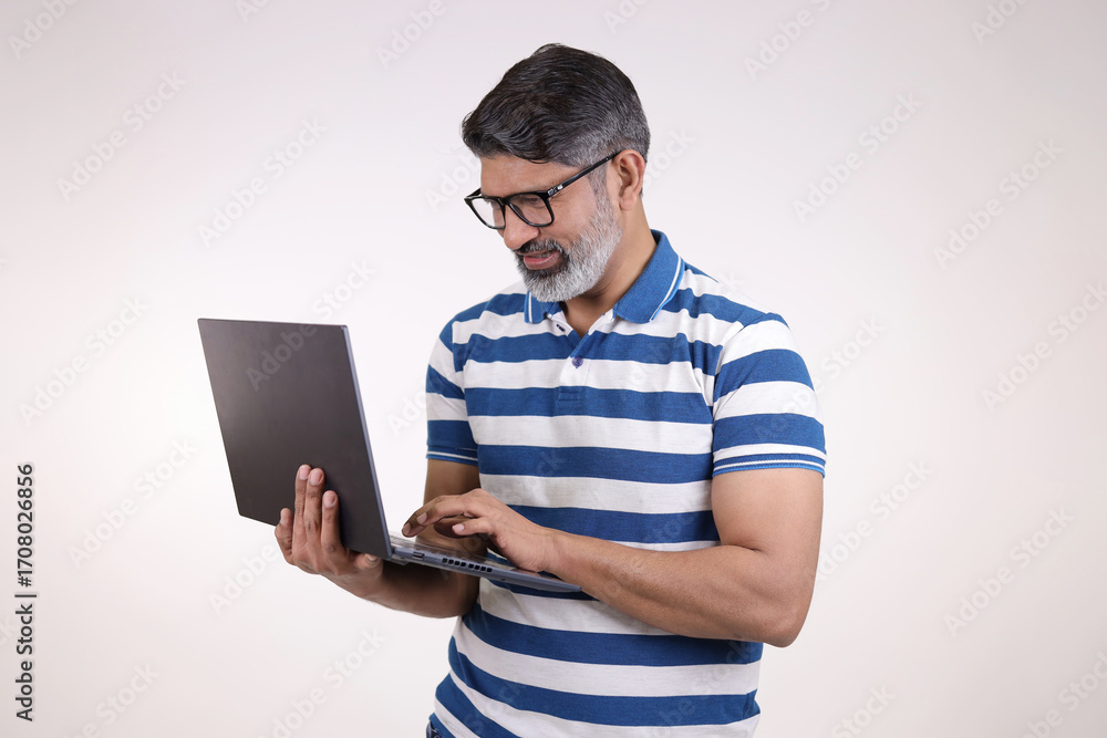 Portrait of a Indian handsome middle aged man working on laptop on ...