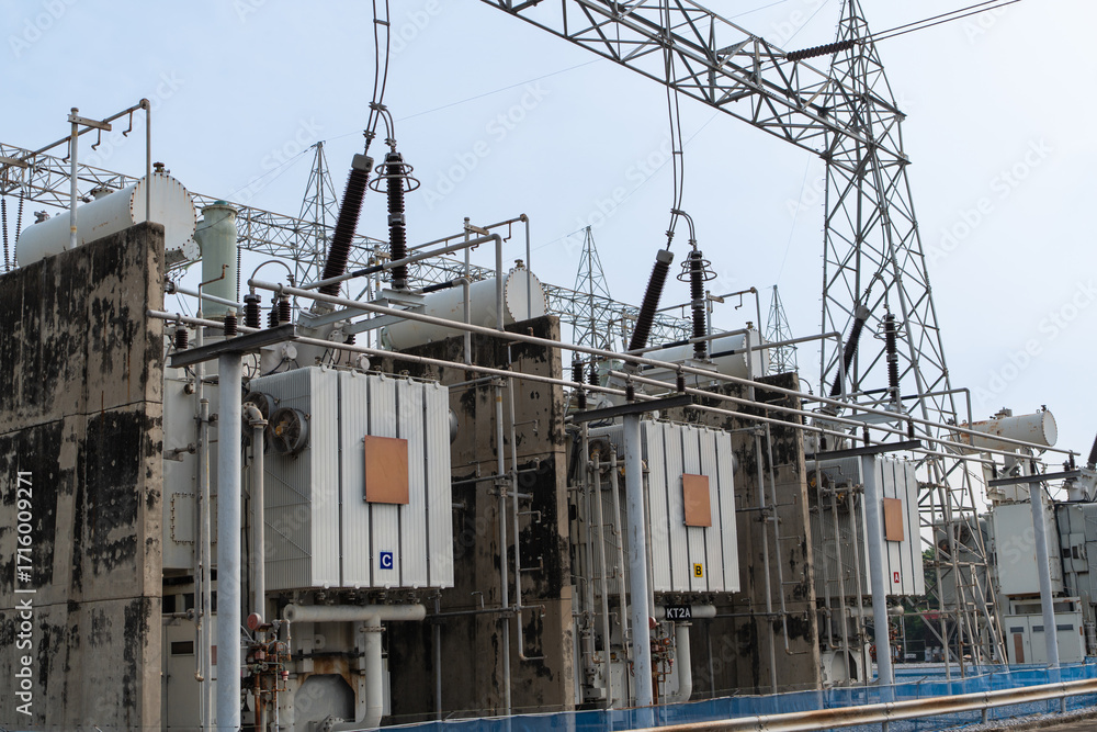 Row of high voltage power transformers in electrical substation with ...