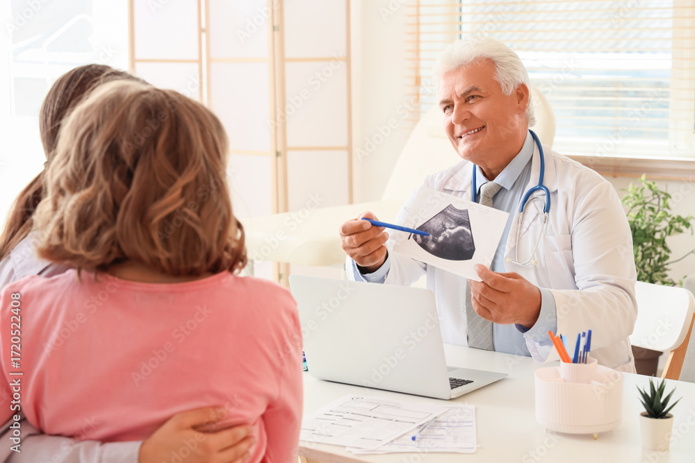 Male fertility doctor showing sonogram image to lesbian couple after ...