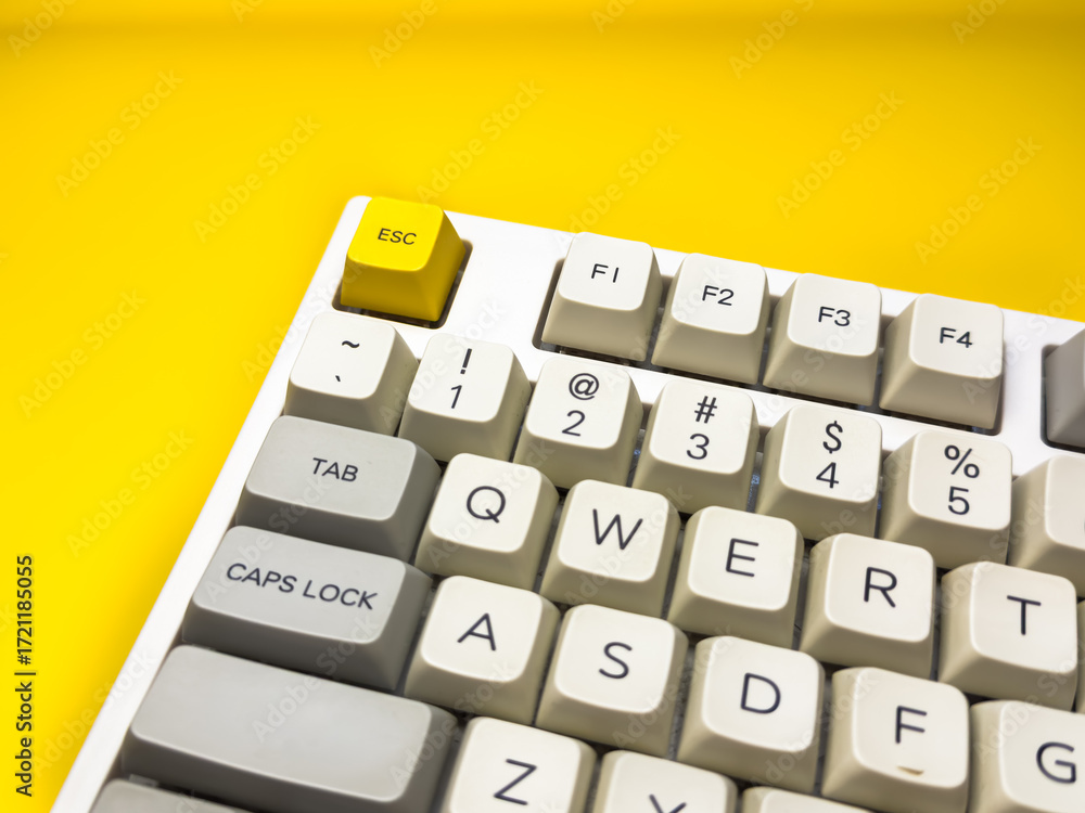 White mechanical keyboard with bright Esc key on bright yellow ...