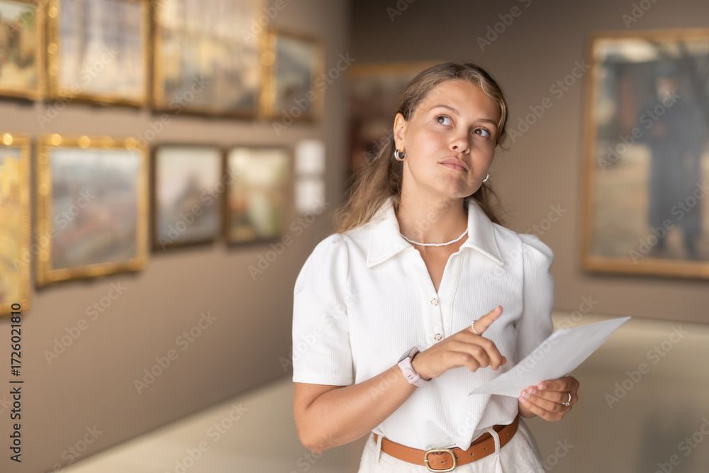 Girl with guidebook walk along exhibition pavilion, get acquainted with ...