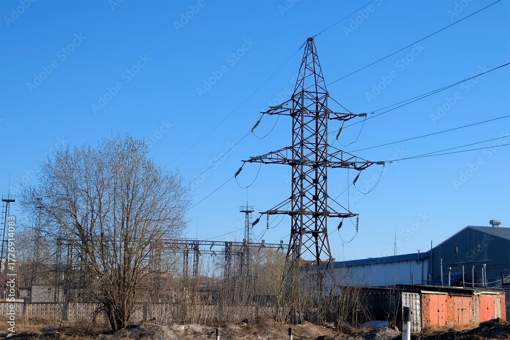 High voltage electric tower on sunny sky background in village ...