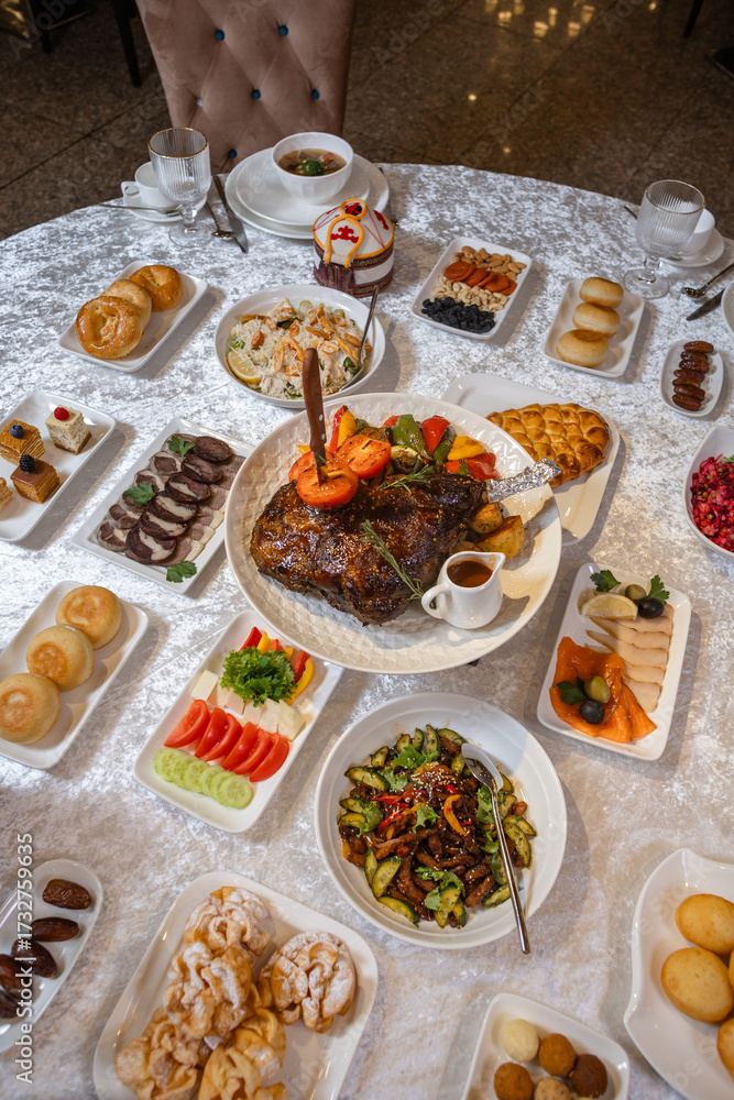 Top view of a lavish banquet table with roasted meat, salads, desserts ...