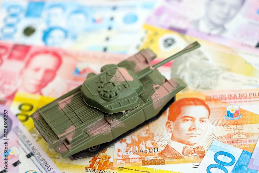Philippines peso currency money bills and toy tank. The concept of army ...