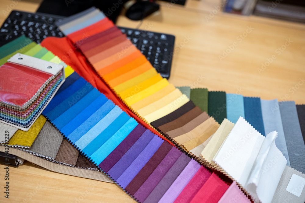 Colorful fabric swatch books on a designer's desk. A concept of ...