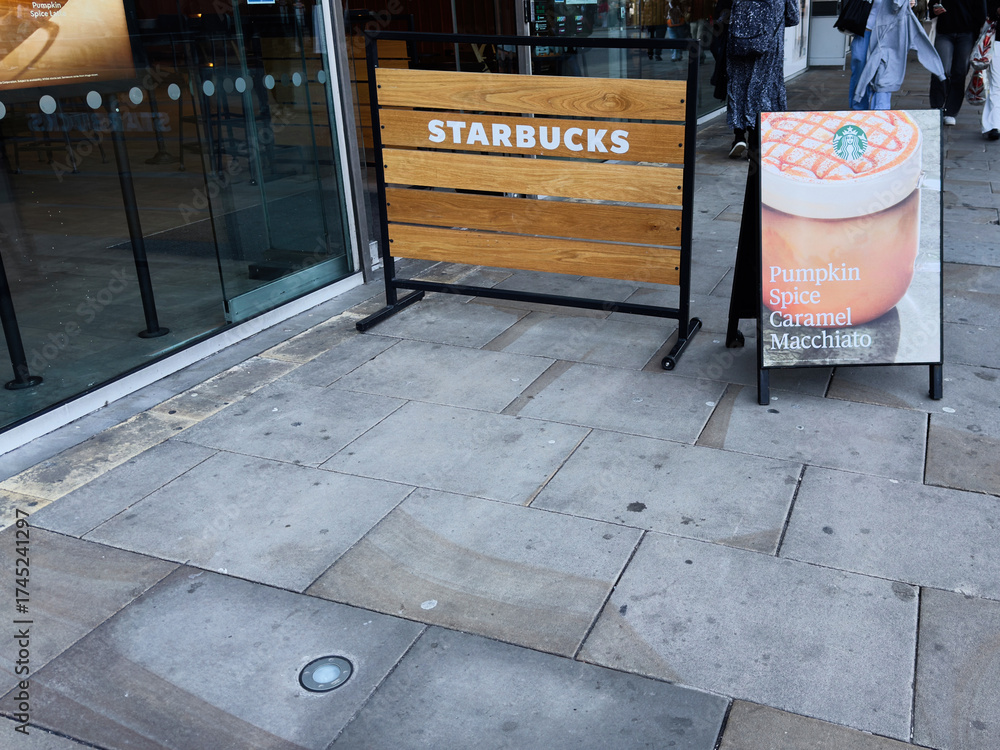 Starbucks storefront on city street with pumpkin spice latte sign and ...
