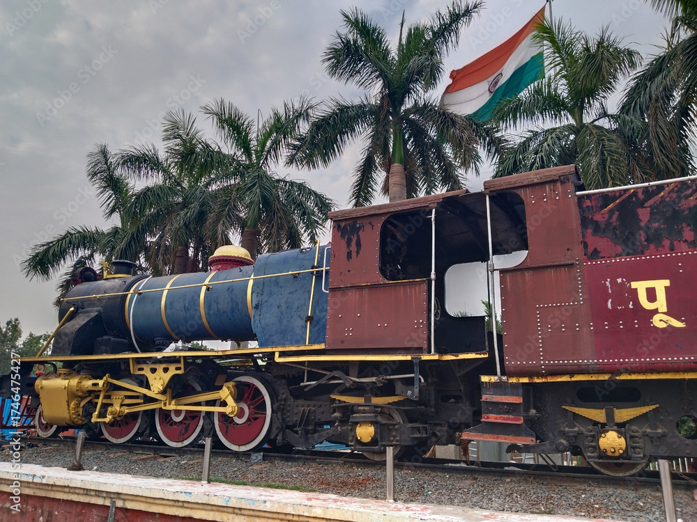 Vintage Indian steam locomotive on outdoor display with national flag ...