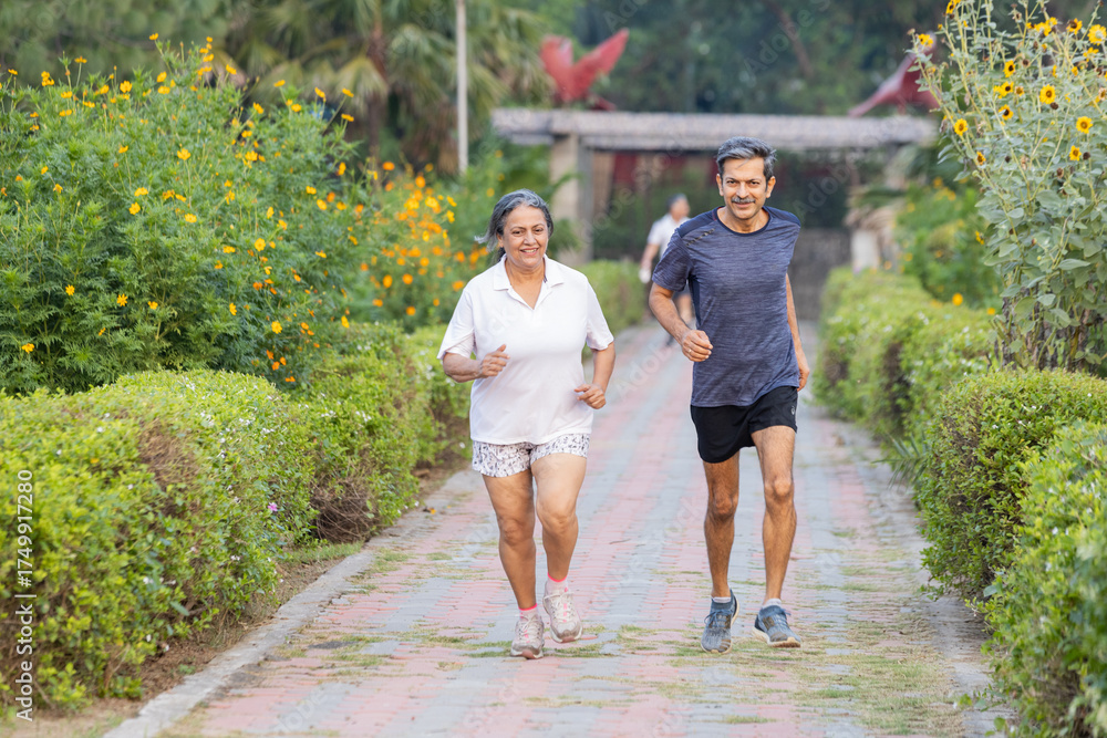 Active Indian senior couple jogging outdoors staying healthy and happy ...