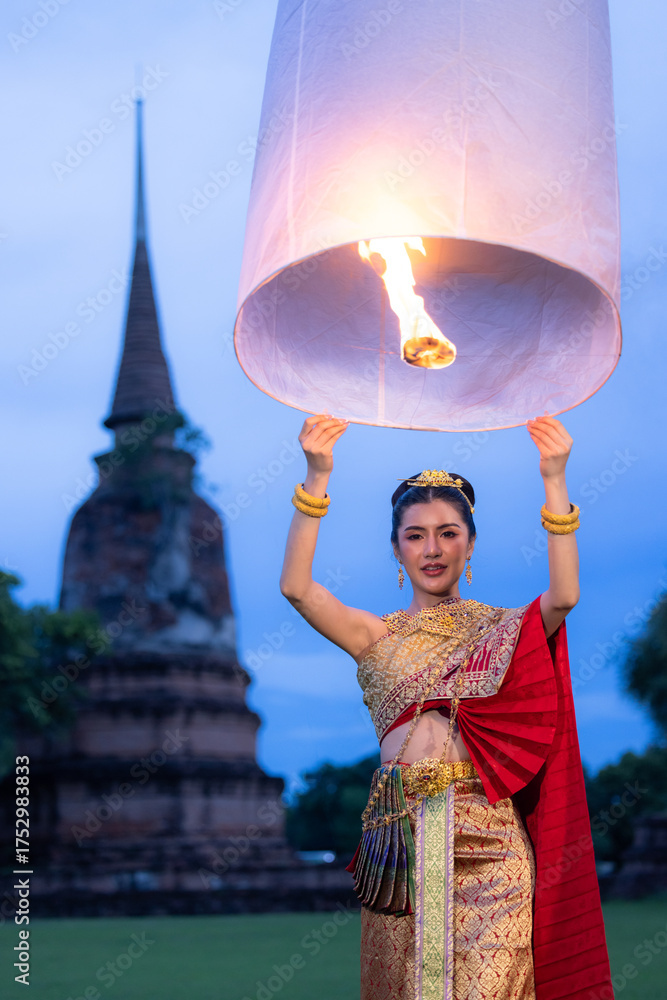 Asian women wearing thai dress releasing sky lantern into the night sky ...