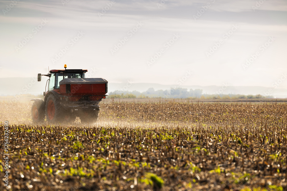 Tractor spreading artificial fertilizers in field Stock Photo | Adobe Stock