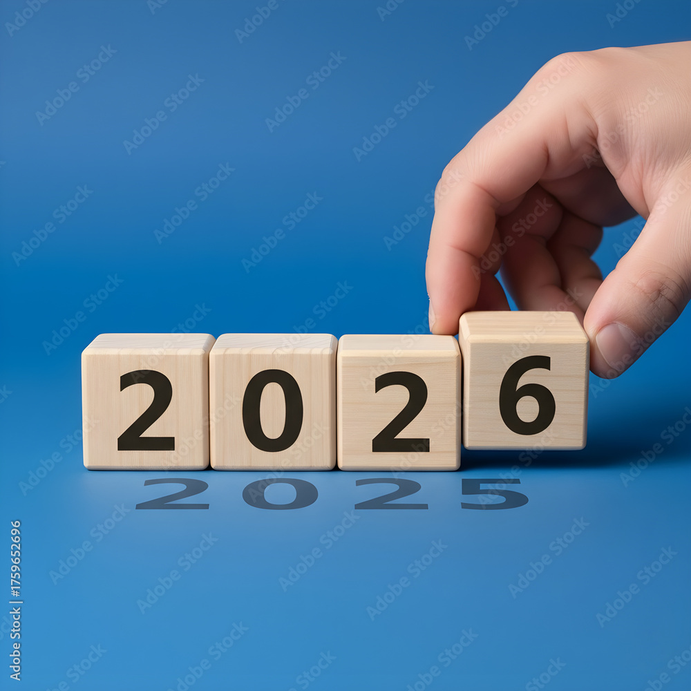 Wooden calendar cubes changing from 2025 to 2026 on blue background ...