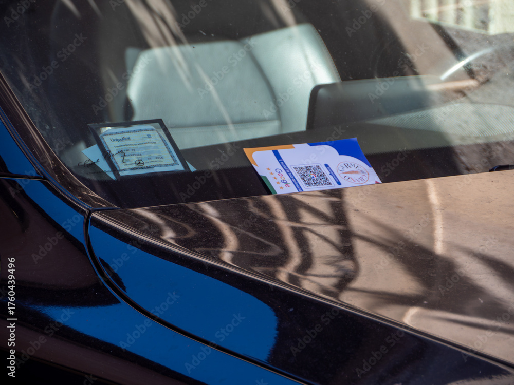 Black car with parking permit and QR code sticker on dashboard ...