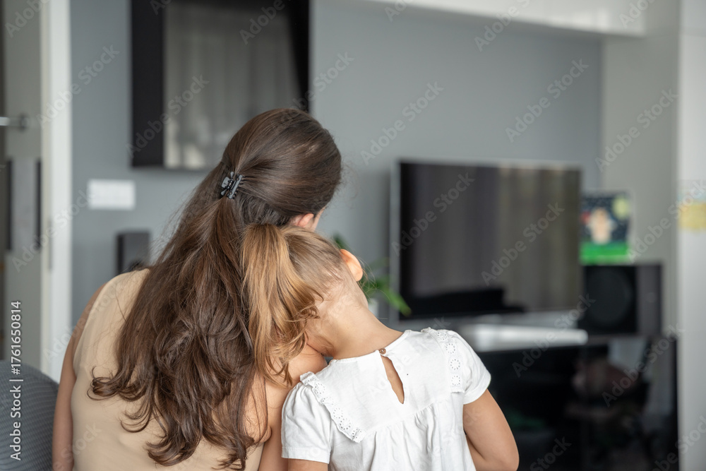 Mother and daughter gently lean their heads together in a quiet moment ...