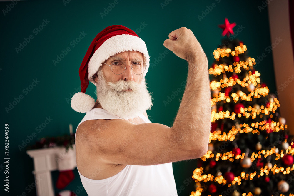 Foto de Stock Elderly man dressed as santa claus flexing muscle by a ...