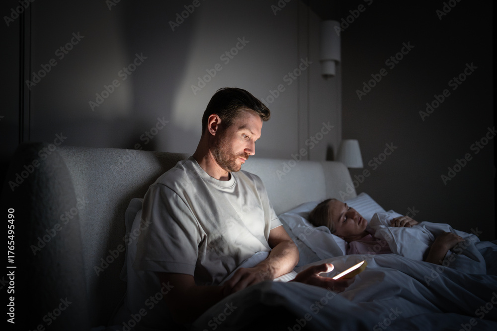Stressed man awake at night using smartphone during sleepless hours in ...