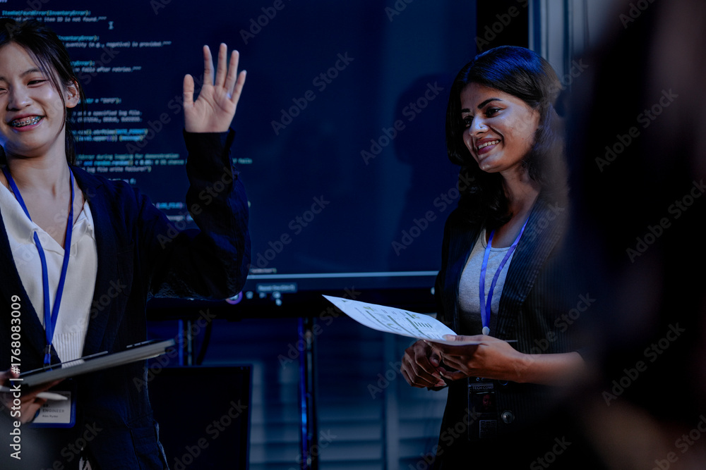 An Indian female developer leads a code review, holding a report. She ...