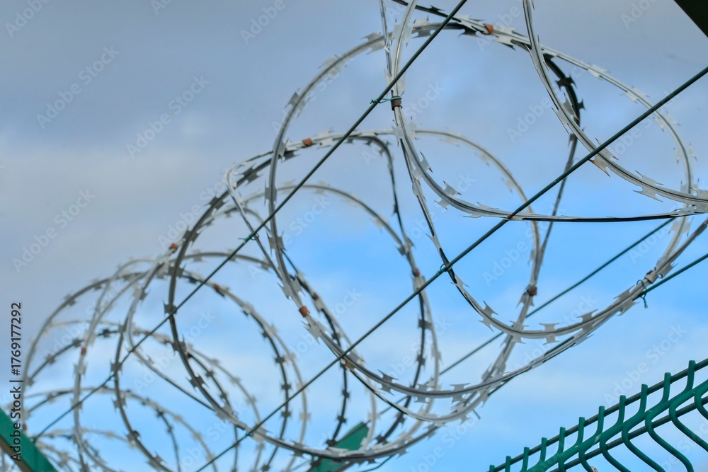 Barbed razor wire on a high-security building. Barbed wire and hard ...