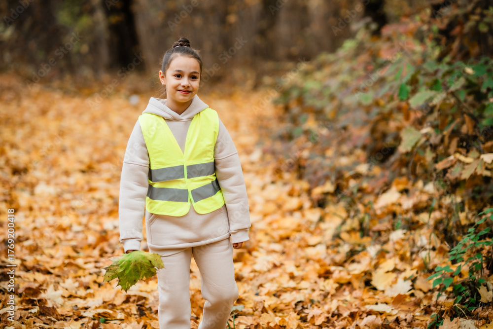 Little girl wearing reflective vest smiling looking to the camera ...